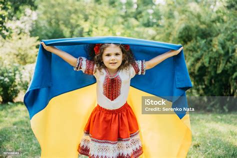 우크라이나 어 어린이 소녀 자수 셔츠 Vyshyvanka 와 노란색과 파란색 플래그 우크라이나 필드에서 8월에 대한 스톡 사진