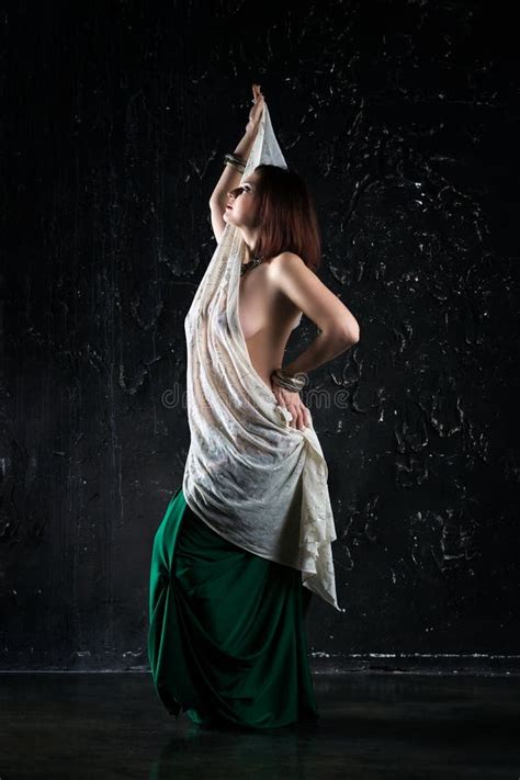 Women Performs Belly Dance In Ethnic Dress On Black Background