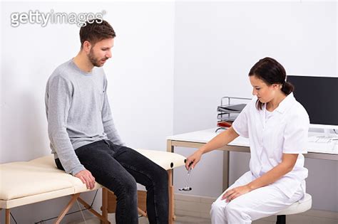 Doctor Checking Knee Reflexes Of Patient With Reflex Hammer 이미지