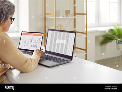 Senior Woman Using Spreadsheets And Calendar App On Laptop To Plan Work