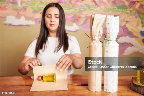 중소 기업에서 일하는 라틴 중반 성인 여성은 그녀의 제품 중 하나를 종이로 포장합니다 30 34세에 대한 스톡 사진 및 기타 이미지 30 34세 30 39세 40