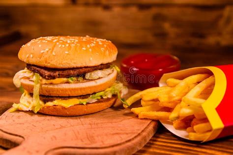 Hamburger E Batatas Fritas Na Tabela De Madeira Imagem De Stock