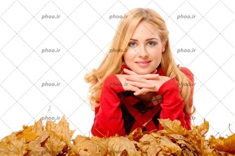 عکس با کیفیت دختر زیبا با مو های طلایی و لباس قرمز در کنار برگ های پاییزی عکس با کیفیت و