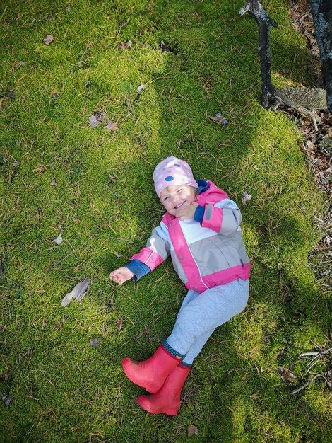 Premium Photo High Angle Portrait Of Laughing Girl Laying On Field
