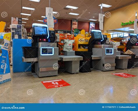 Signs Instructing Social Distancing At The Self Checkout Lines At A