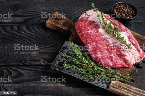 신선한 생 라운드 로스트 쇠고기 고기 는 칼과 정육점 도마에 잘라 검은 색 나무 배경 맨 위 보기입니다 복사 공간 등심