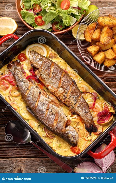 Baked Trout With Lemon Sauce And Vegetables In A Pan Stock Image