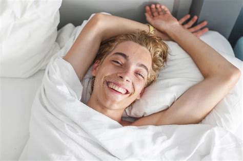 Joven Y Apuesto Hombre Feliz Despertándose En La Cama Por La Mañana