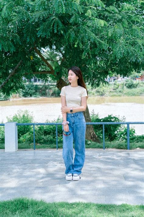 有关休閒 休闲装 公園 和平的 在公园里的女人 城市环境 夏天 天性 娛樂 寧靜 年輕女子 快樂 戶外 户外运动 放鬆 新鲜空气 日光 晴天 樹木 牛仔布