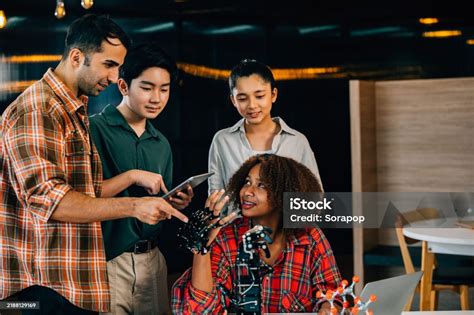 학생들과 교사들이 교실에 모여 학습용 로봇 팔을 탐색하고 있었습니다 과학과 기술에 대한 혁신 팀워크 및 실용적인 교육을 강조합니다 로봇 손 기술 개념 14 15 살에 대한