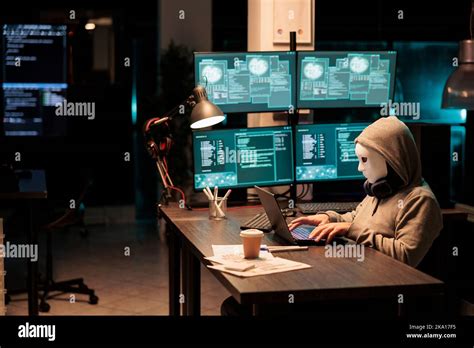 Scammer With Mask And Hood Hacking Security Server Installing Virus To