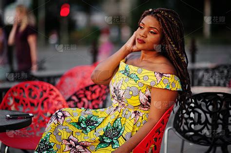 可爱的小个子非裔美国女孩，梳着发辫，穿着黄色的连衣裙