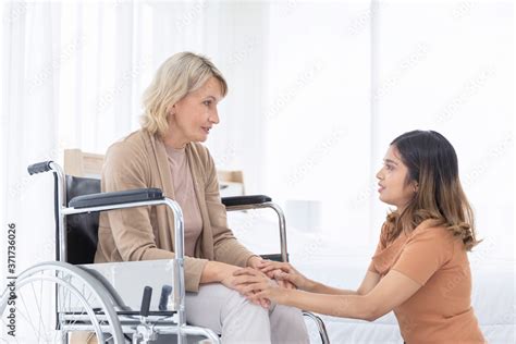 Mother And Her Adopted Daughter Take Care Her On A Wheelchair With