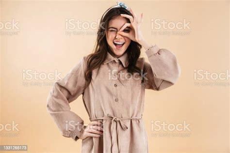 베이지 색 배경 벽위에 고립 된 포즈를 취하는 행복한 젊은 예쁜 여자는 괜찮은 제스처를 합니다 20 29세에 대한 스톡 사진 및