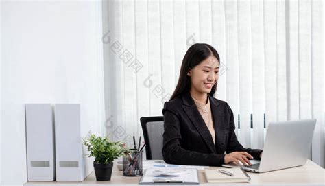 亚洲女商人坐在她们的办公桌前计算显示她们图片 包图网企业站