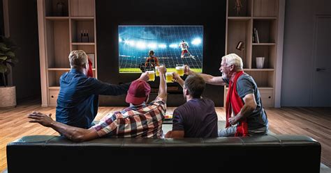 팬 들의 그룹 축구 순간 Tv와 거실에서 소파에 앉아 목표 축 하에 보고 있다 Soccer Tournament에 대한 스톡 사진