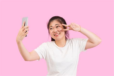 귀여운 아시아 여자 Selfie 복용 스마트 휴대 전화 카메라 아름 다운 게시 멋진 미소 소셜 미디어 십 대 소녀 흰 셔츠 핑크