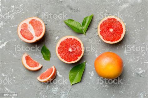 색으로 칠해진 배경에 육즙이 많은 자몽 슬라이스가 있는 신선한 과일 자몽 맨 위 보기입니다 공간을 복사합니다 창조적 인 여름 개념 복사 공간이있는 최소한의 평평한 평지에