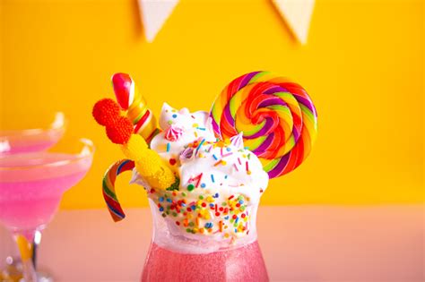 카라멜 밀크 쉐이크 칵테일 레모네이드와 휘핑 크림 컬러 달콤한 사탕과 막대 사탕을 유리에 넣습니다 아이스크림에 대한 스톡 사진