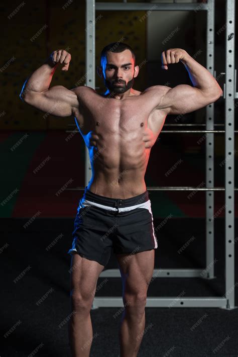 Premium Photo Young Bodybuilder Flexing Muscles Double Biceps Pose