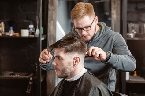 금속 가위로 머리를 자르는 마스터는 이발소에서 남자의 머리와 수염을 잘라 미용사는 젊은 남자를위한 헤어 스타일을 만든다 2명에 대한 스톡 사진 및 기타 이미지 Istock