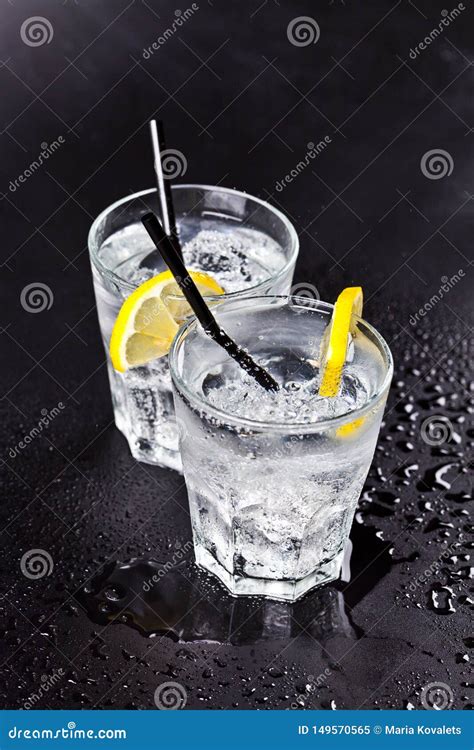 Two Glasses Of Fresh Cold Carbonated Water With Ice Cubes And Lemon