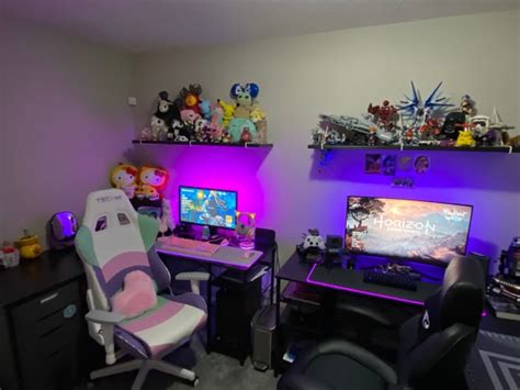 A Room With Two Computer Desks And Purple Lighting
