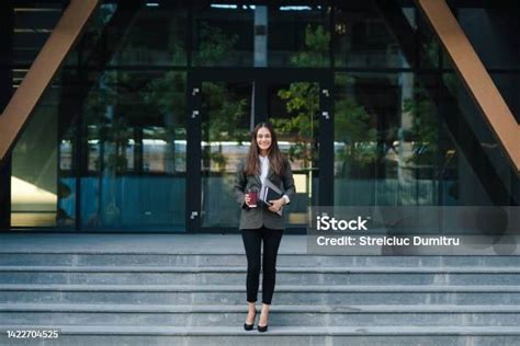 계단을 걸어 내려가 노트북을 들고 테이크 아웃 커피를 마시는 사업가의 정면 모습 비즈니스 성공 개념 비즈니스 라이프 스타일 개념 사람들의 라이프 스타일 개념 도시 배경 전체