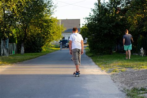 거리에서 스케이트 보드에 재생 디포커스 행복한 어린 소년 배경에 개와 함께 걷는 남자 코카서스 아이는 페니 보드를 타고 스케이트 보드를 연습 어린 시절 재미 자유 개념