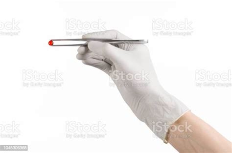 약 학 및 의학 테마 빨간 알 약 캡슐 스튜디오에서 흰색 배경에 고립으로 족집게를 들고 흰 장갑에 의사의 손을 강철에 대한 스톡
