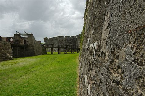 흐린 하늘 아래 나무 다리와 잔디밭이 있는 유서 깊은 석조 요새 미국 플로리다주 세인트오거스틴 0명에 대한 스톡 사진 및 기타 이미지 Istock