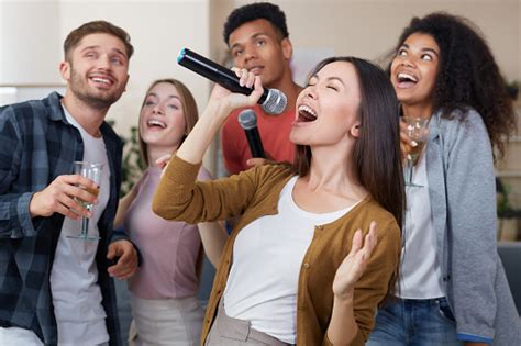 노래 하는 소녀입니다 젊은 아름 다운 아시아 여자 들고 마이크와 노래 하는 동안 재미 와 함께 집에서 집에서 노래방 을