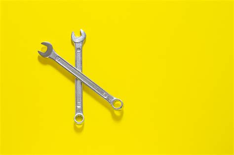 노란색 배경에 스 패너 키 스크류 드라이버 세트 렌치 스 패너는 문자 X의 모양으로 서로 거짓말을 합니다 텍스트 및 디자인에 대