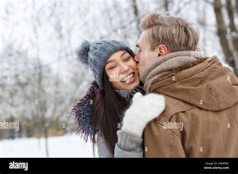 Guy Kissing His Girlfriend On Cheek In Embrace Stock Photo Alamy