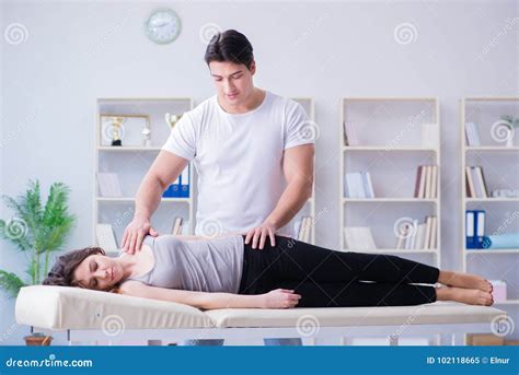 The Young Doctor Chiropractor Massaging Female Patient Woman Stock