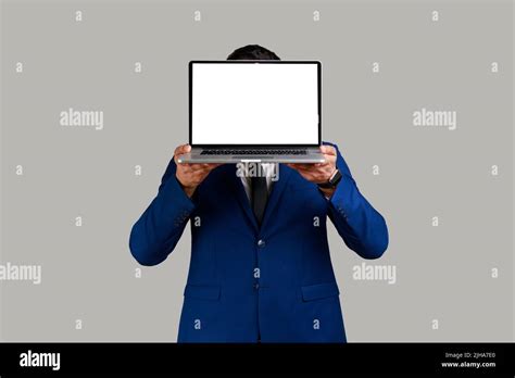 Anonymous Unknown Man Hiding His Face Behind Laptop With White Blank Display With Space For
