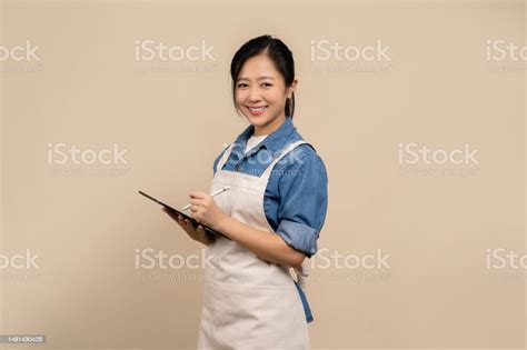 앞치마를 두른 쾌활한 아시아 여성 손에 태블릿을 들고 스튜디오를 배경으로 격리 중소기업 시작 개념입니다 30 34세에 대한 스톡