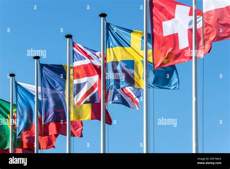 Flags Of European Countries On Flagpoles Flying In The Wind Against