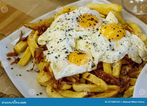 Typical Spanish Food Fried Eggs Chips And Ham Scrambled Eggs Stock