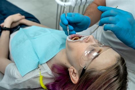 Premium Photo Professional Male And Female Dentists Treat A Womans