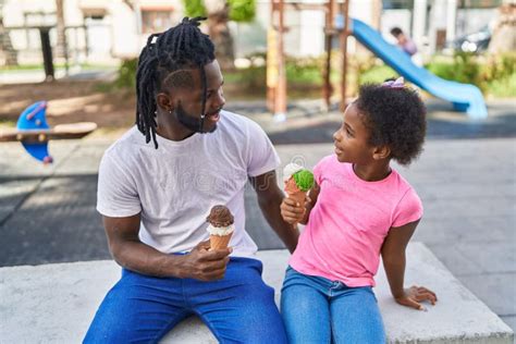 Padre E Hija Comiendo Helados Sentados Juntos En El Banco Del Parque Imagen De Archivo Imagen