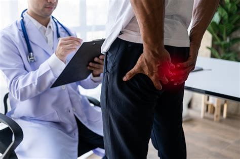치질로 고통받는 젊은 남자는 의사와 상담한다 복통과 치질 건강 관리 개념 때문에 엉덩이를 만지는 남자 복부에 대한 스톡 사진 및 기타 이미지 Istock