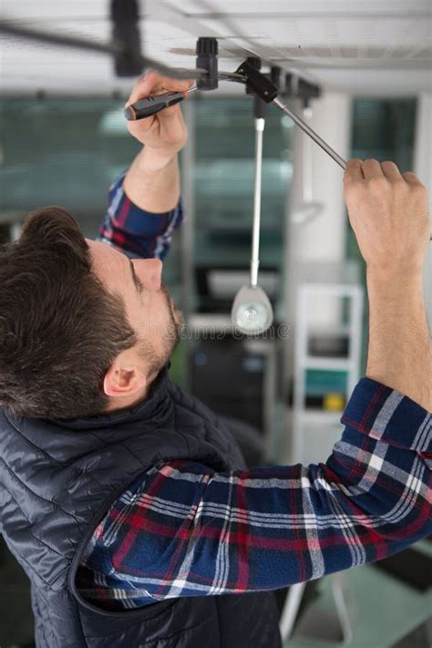 Portrait Male Electrician Fixing Light On Ceiling Stock Image Image Of Finger Checking