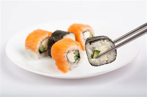 Rollo De Sushi Sobre Palillos Con Rollo De Sushi Sobre Placa Blanca