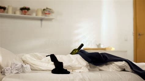 Lingerie And Bottles Lying On Bed After Students Home Party Cleaning Service Stock Photo