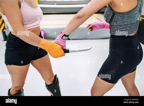 A Woman Performing A Self Defense Move To Remove The Knife From Her