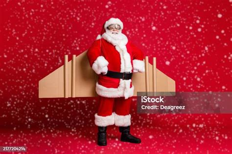 은퇴 한 할아버지의 전체 길이 사진 흰 수염 제트 팩 손 엉덩이 자신감 준비 세계 일주 여행 착용 산타 엑스 마스 의상 코트 안경 모자 절연 빨간색 배경 35 39세에 대한