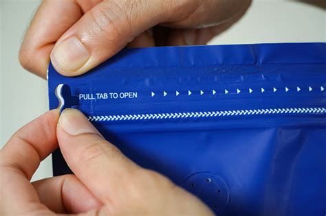 하얀 배경에 차나 커피가 든 파란 공예품 꾸러미를 들고 있는 남자 종이 봉지 드립 커피 필터가 있는 팩 제품용기에 대한 스톡 사진 및 기타 이미지 Istock