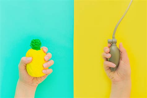 플랫 누워 스트레스 안티 스트레스 장난감 손에 노란색 파인애플 혈압 모니터를 분쇄 밝은 파란색 배경압축 부드러운 짜내는 항목은 완화 문제 불안 걱정 여름 컨셉 개념에 대한