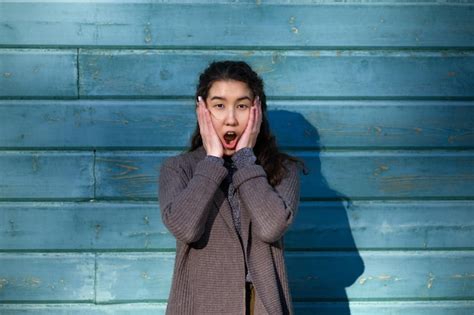 Premium Photo Asian Girl Opens Her Mouth In Surprise And Clasps Her